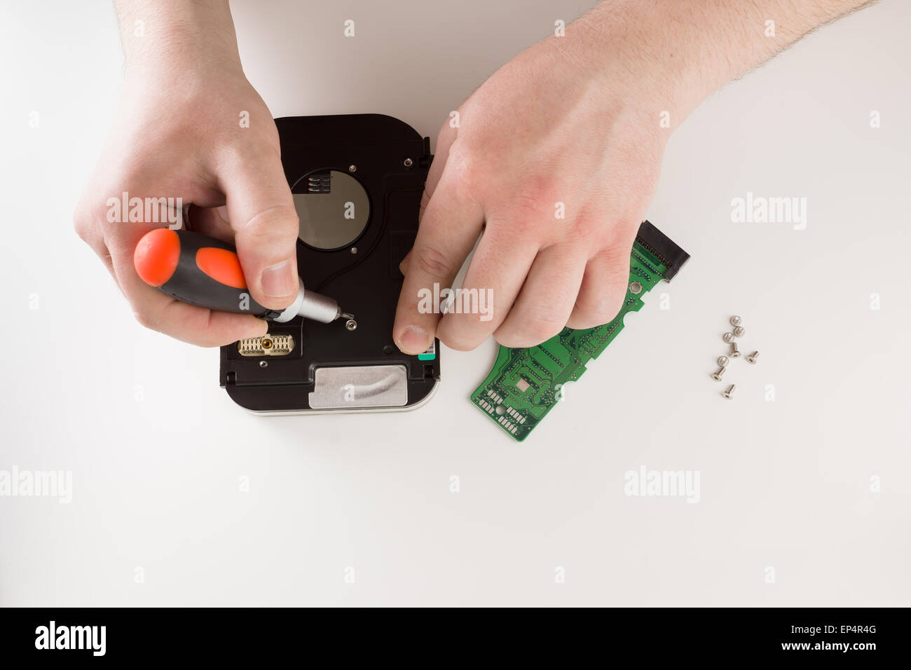 the computer hard drive in the course of dismantling on a white ...