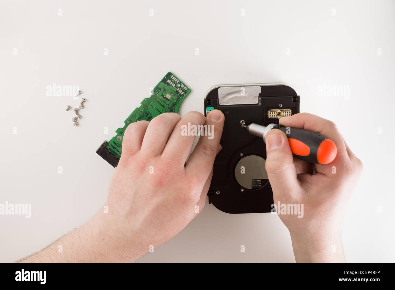 the computer hard drive in the course of dismantling on a white ...