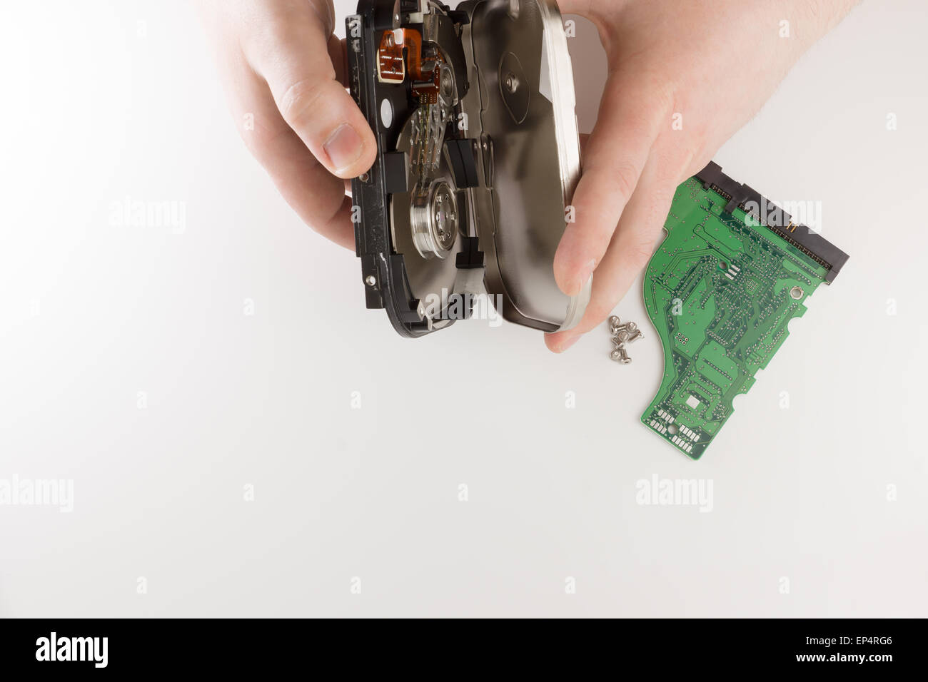 the computer hard drive in the course of dismantling on a white ...