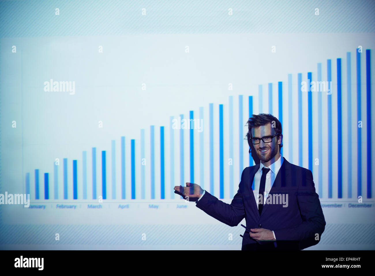 Elegant businessman pointing at chart on the wall Stock Photo - Alamy