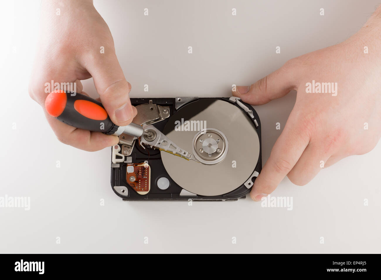 the computer hard drive in the course of dismantling on a white ...