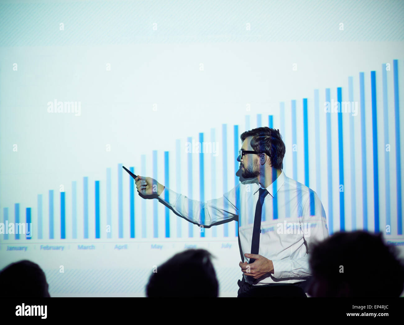 Handsome manager pointing at chart of financial progress Stock Photo ...
