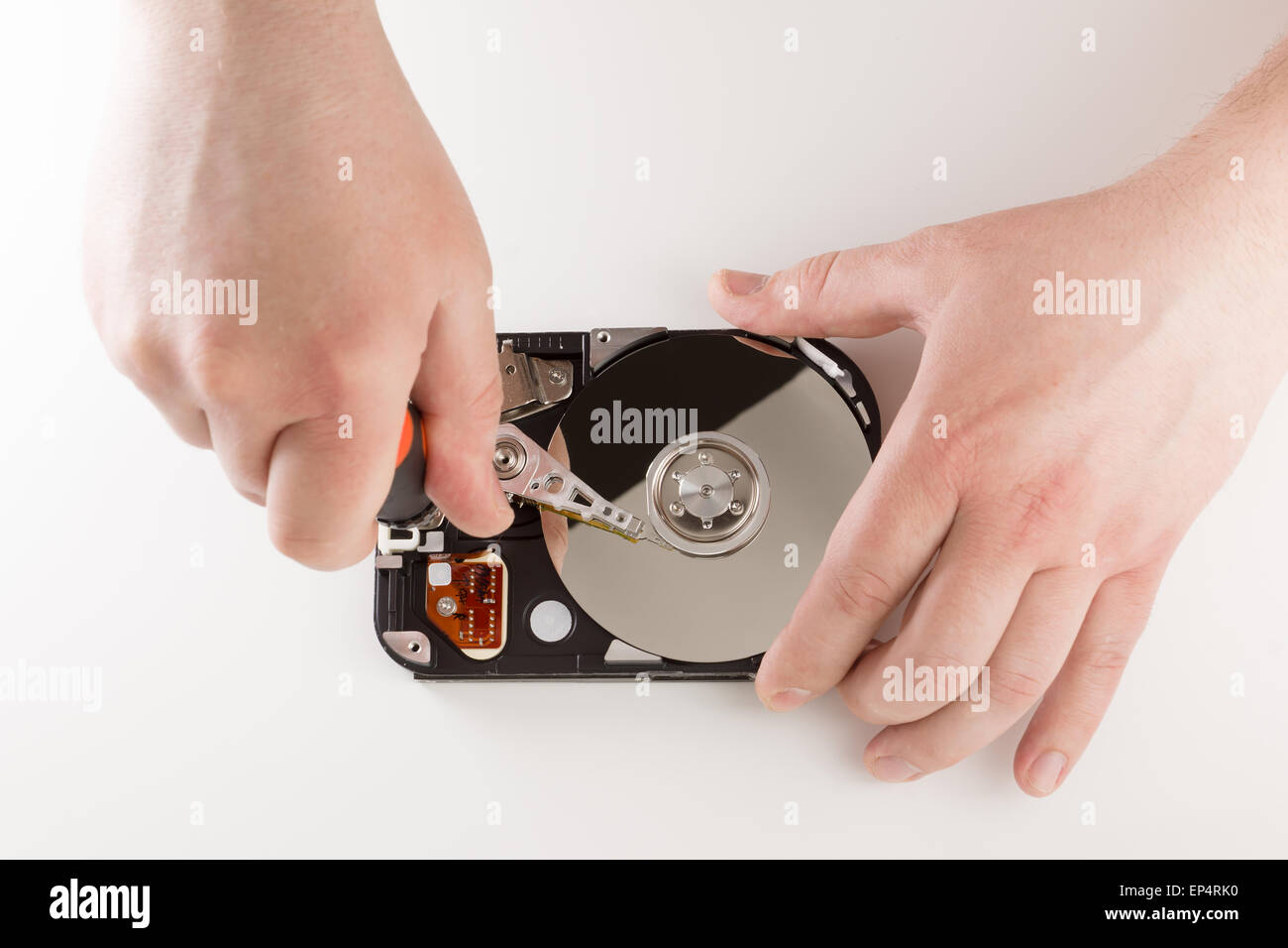 the computer hard drive in the course of dismantling on a white ...