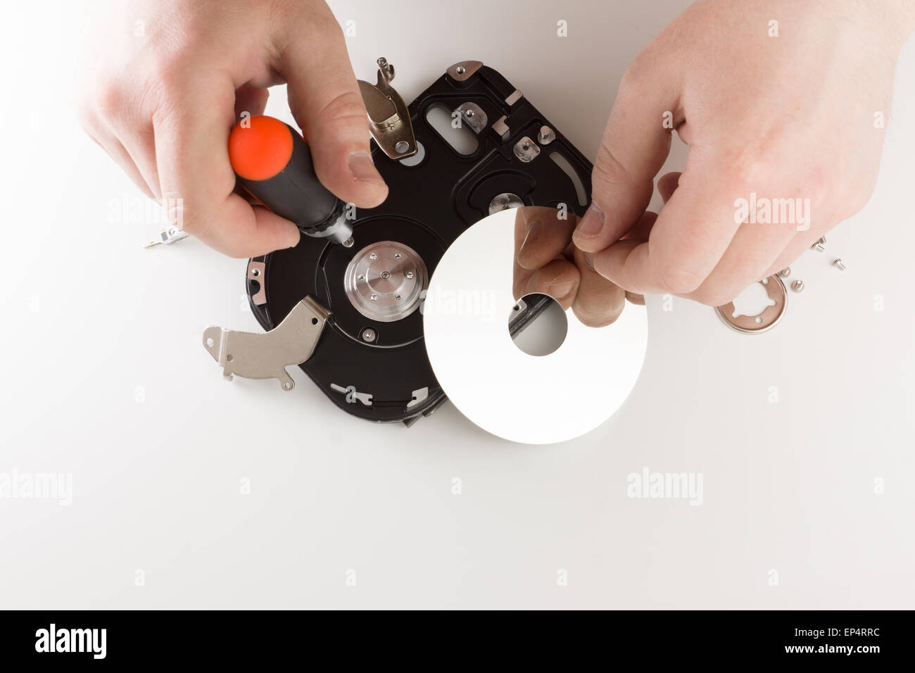 the computer hard drive in the course of dismantling on a white ...