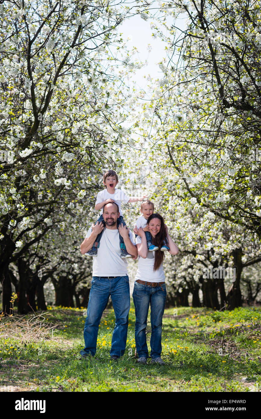 Young happy family in cherry blossom spring garden Stock Photo - Alamy