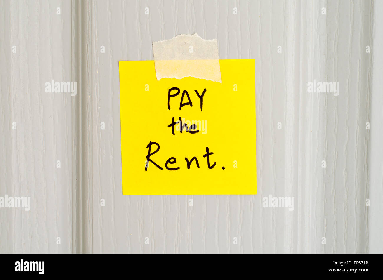 sticky note write a message pay the rent on wood door background Stock ...