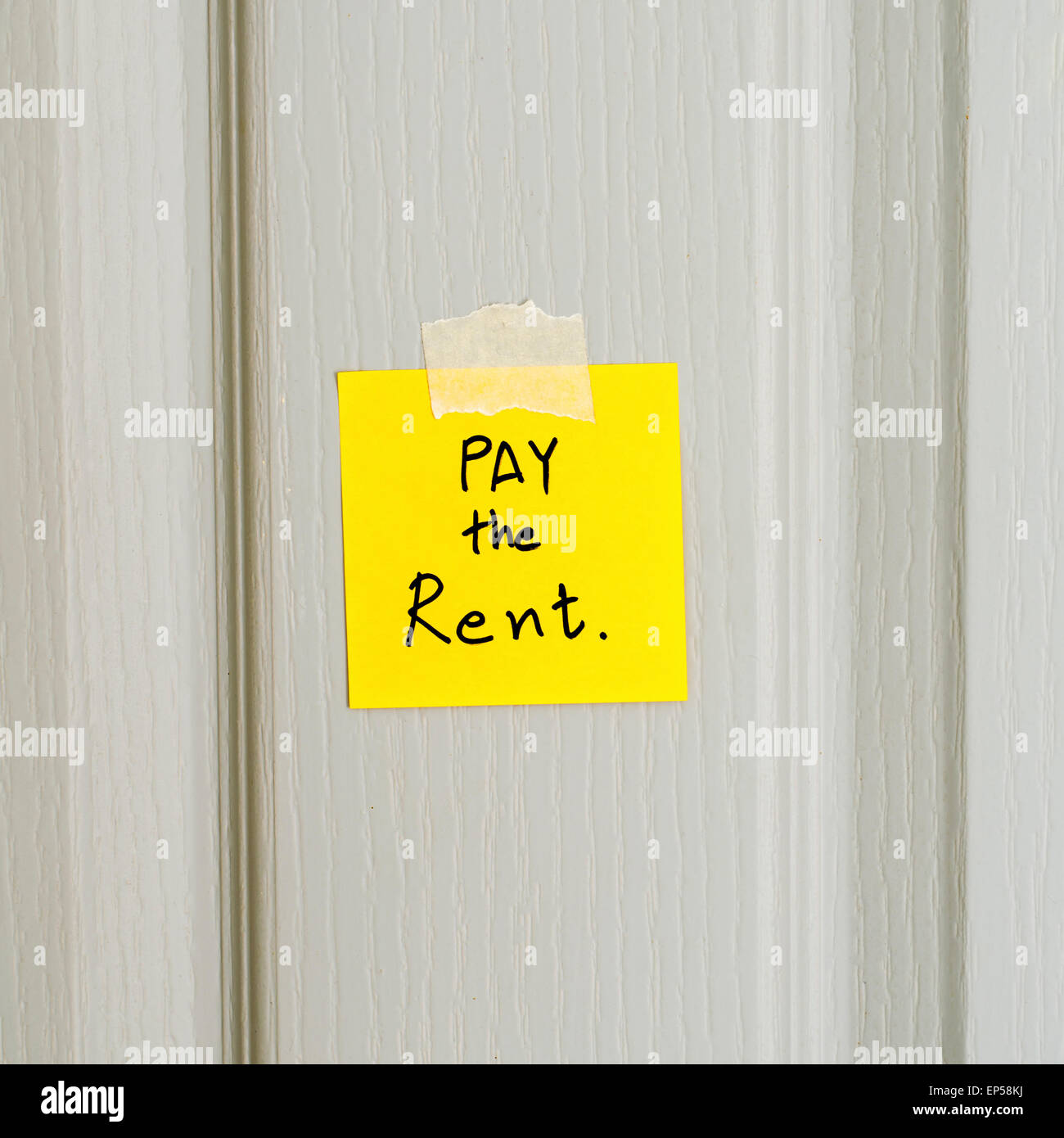sticky note write a message pay the rent on wood door background Stock ...