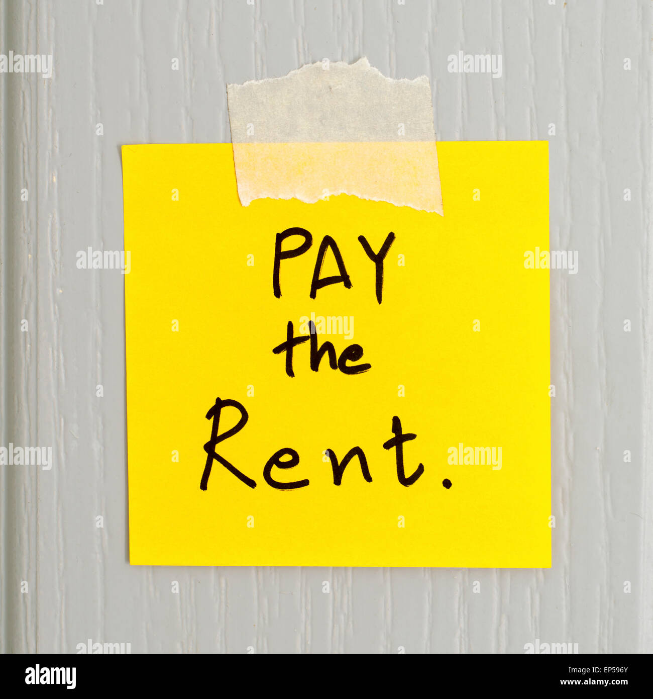 sticky note write a message pay the rent on wood door background Stock ...