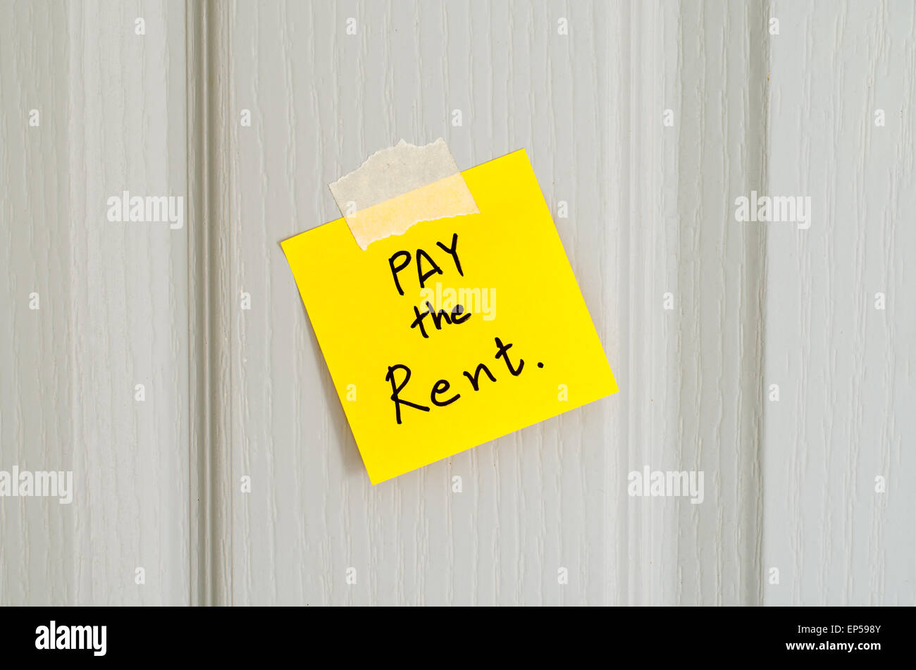 sticky note write a message pay the rent on wood door background Stock ...