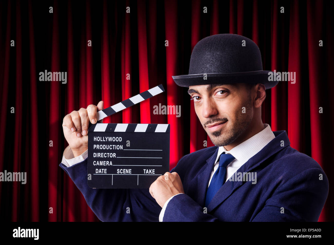 Man with movie clapper on curtain background Stock Photo - Alamy
