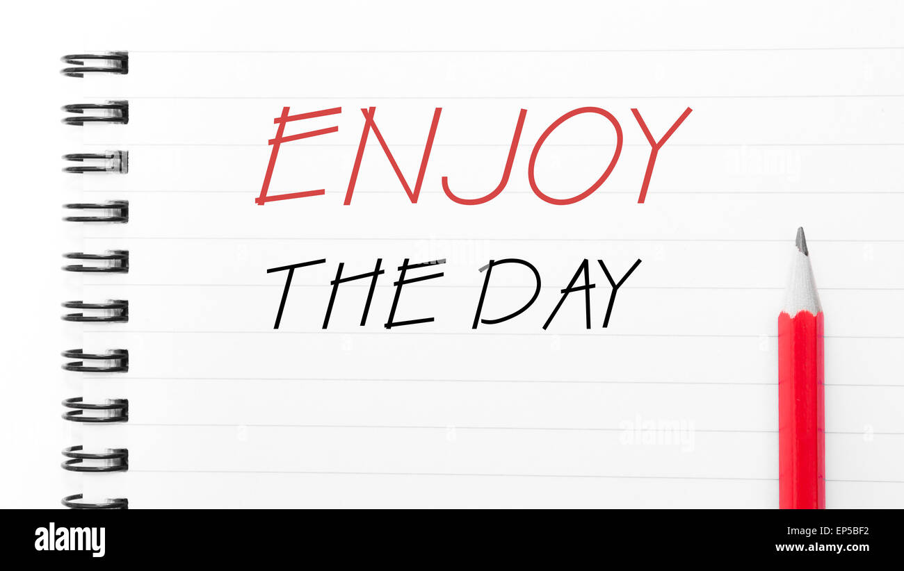 Enjoy The Day Text written on notebook page, red pencil on the right ...