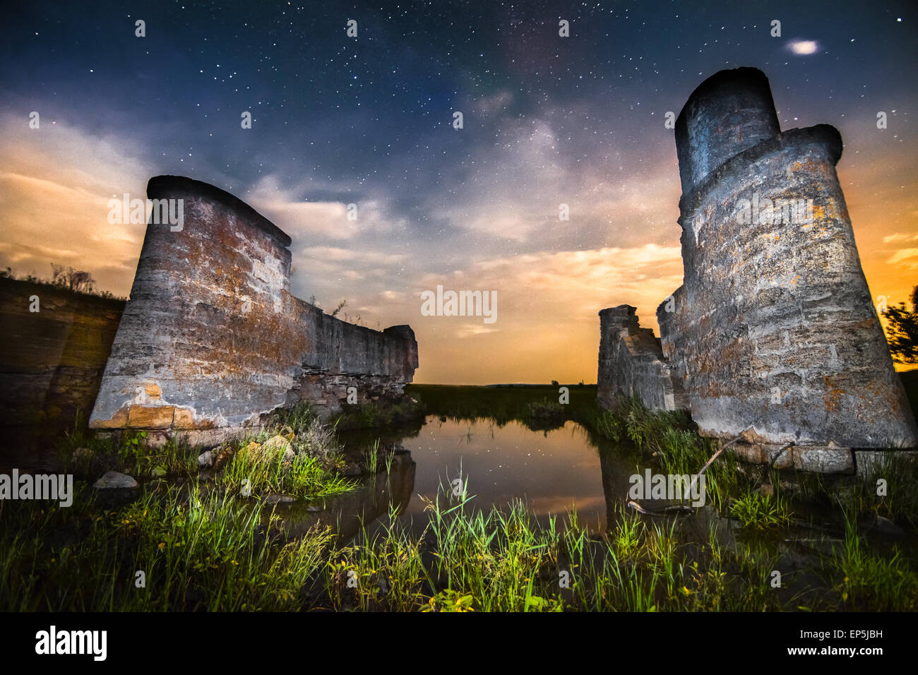 Old night castle wall ruins on lake reflections with stars sky Stock ...