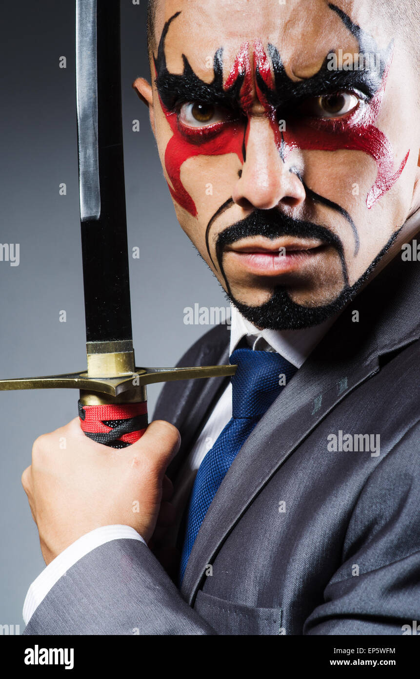 Man with face paint and sword Stock Photo - Alamy