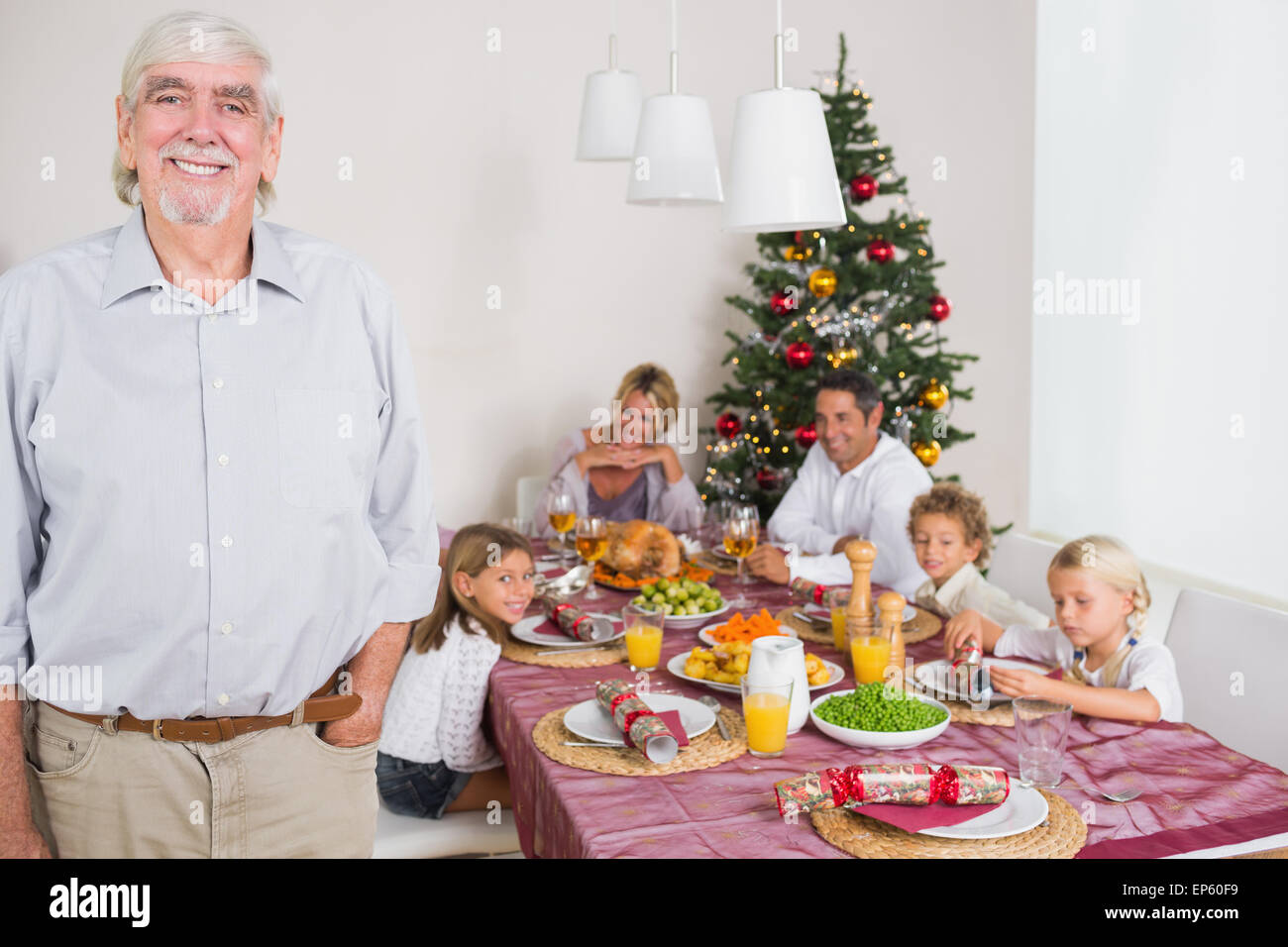 Smiling grandfather standing at the dinner table Stock Photo - Alamy
