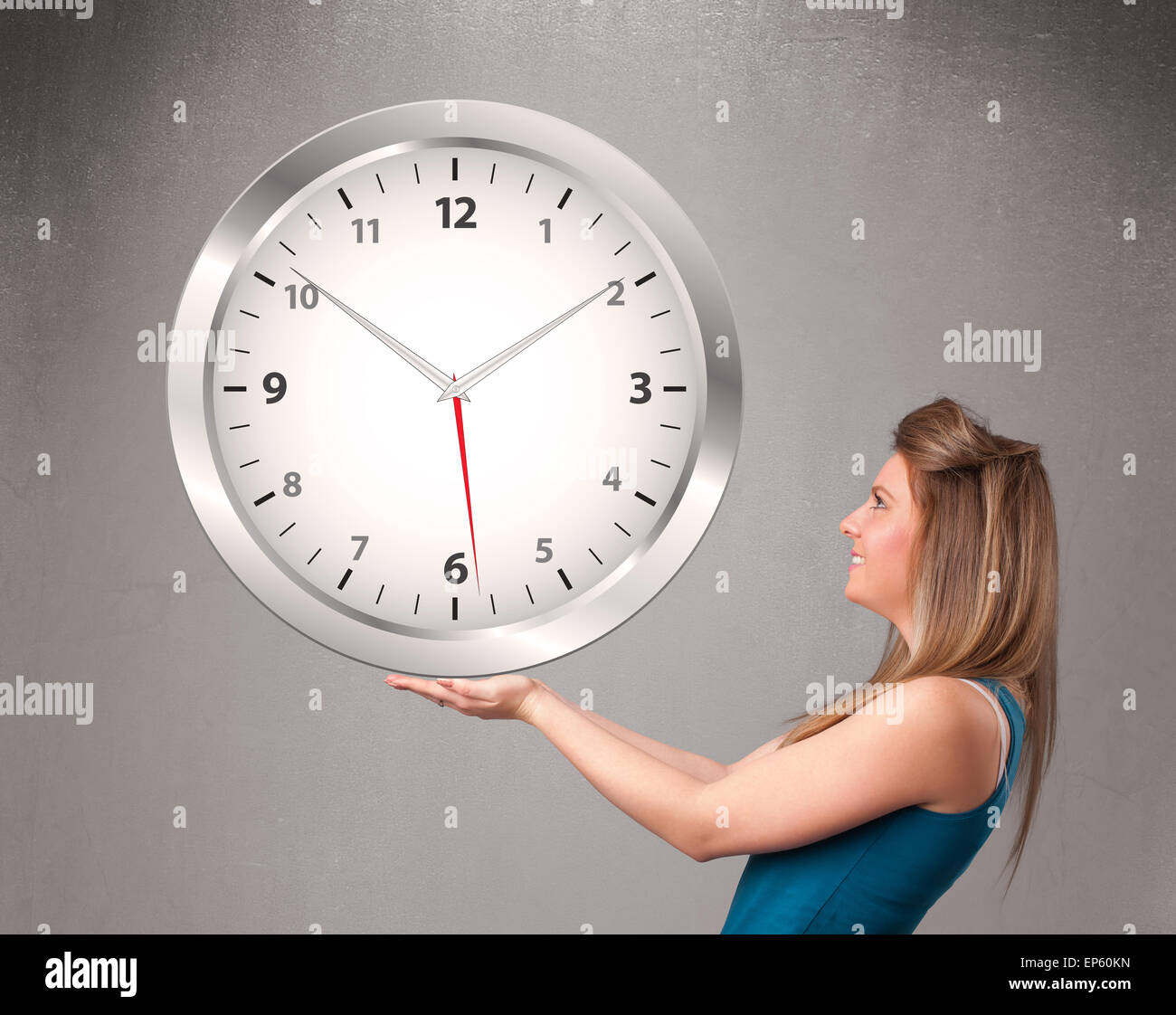 Attractive lady holding a huge clock Stock Photo - Alamy