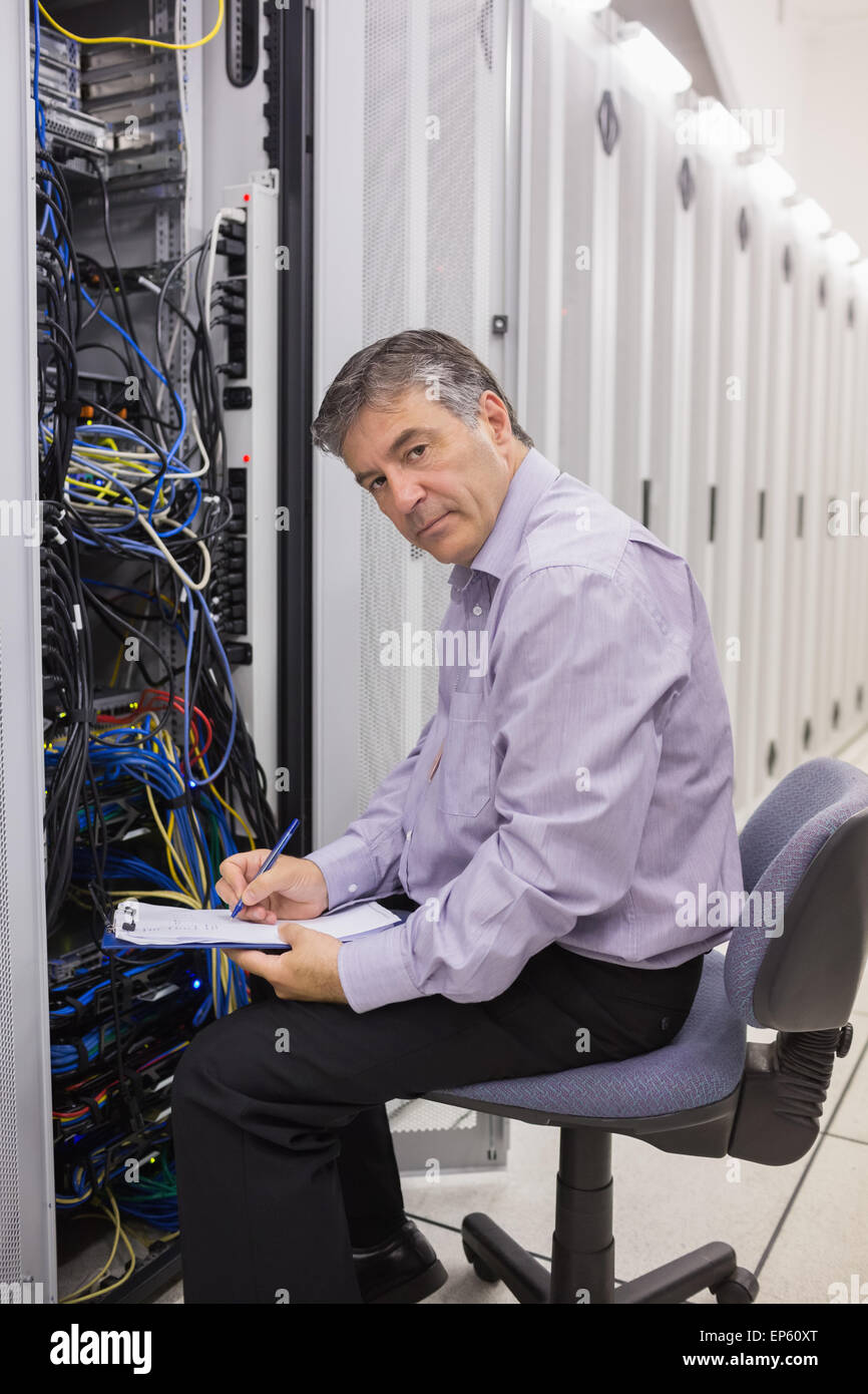 Man checking servers and writing on clipboard Stock Photo - Alamy