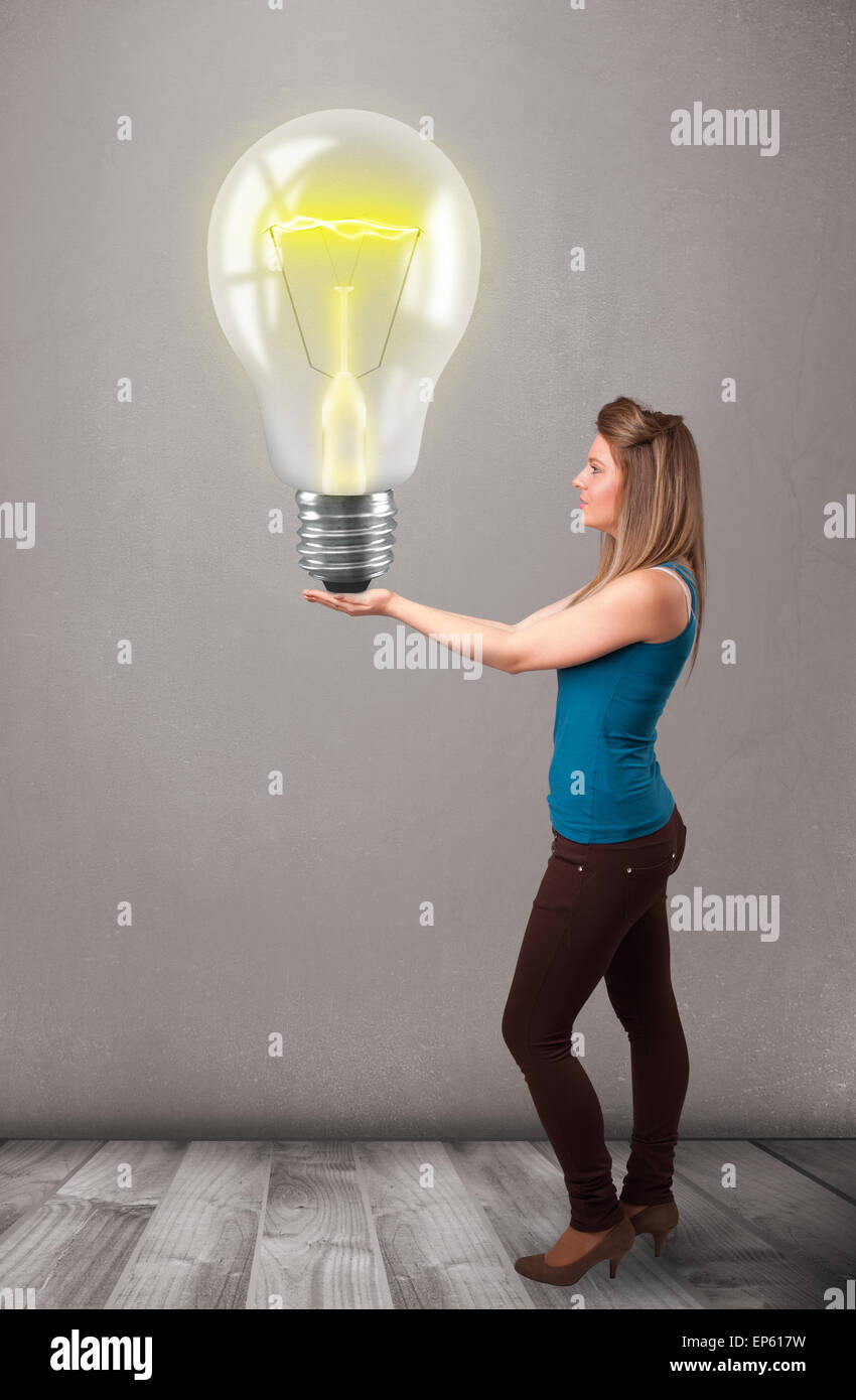 Beautiful lady holding realistic 3d light bulb Stock Photo - Alamy