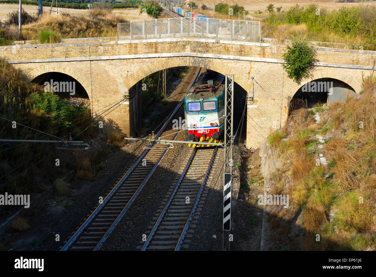 Locomotive train traveling under bridge, Tuscany, Italy Stock Photo - Alamy