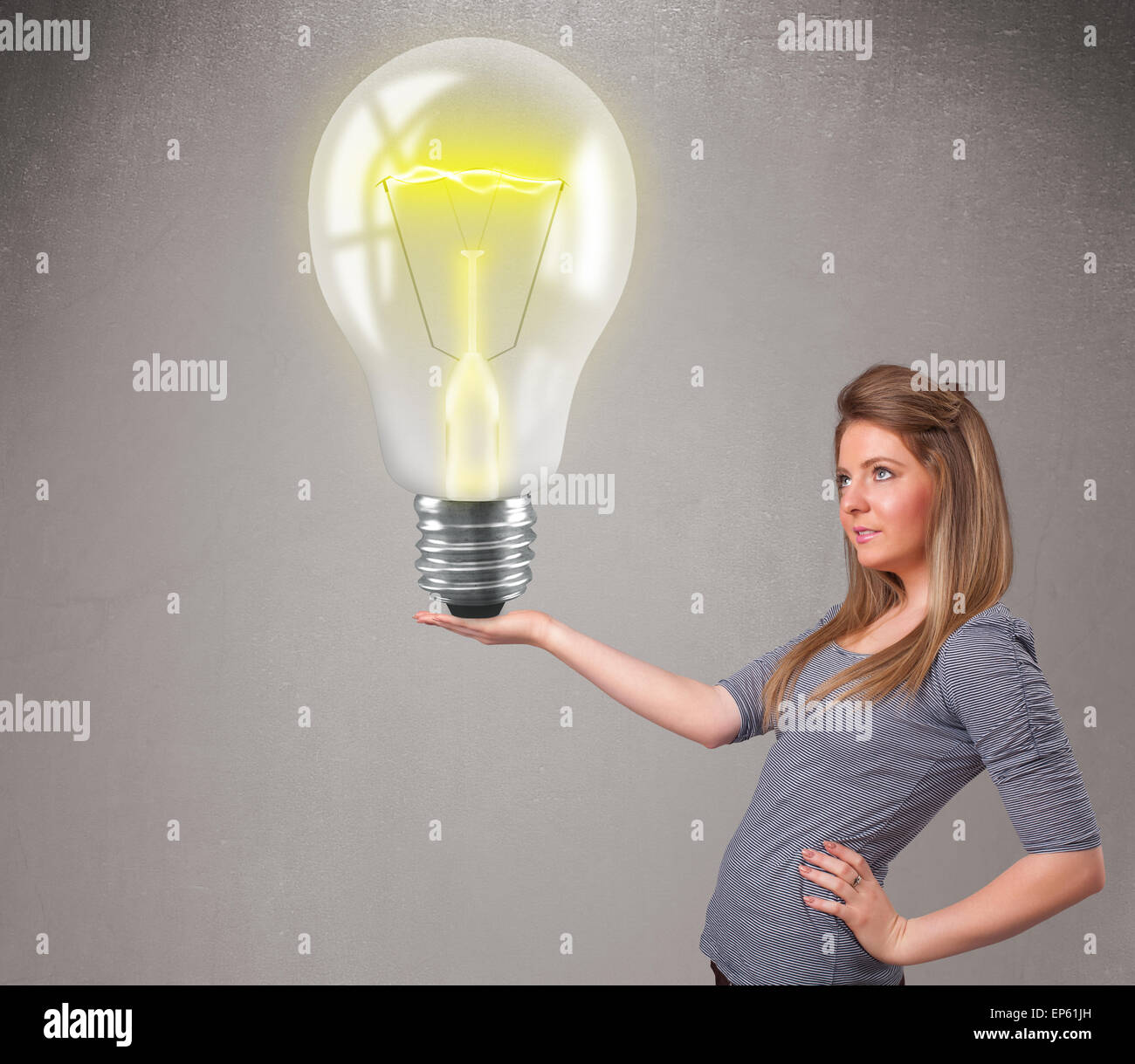 Beautiful lady holding realistic 3d light bulb Stock Photo - Alamy