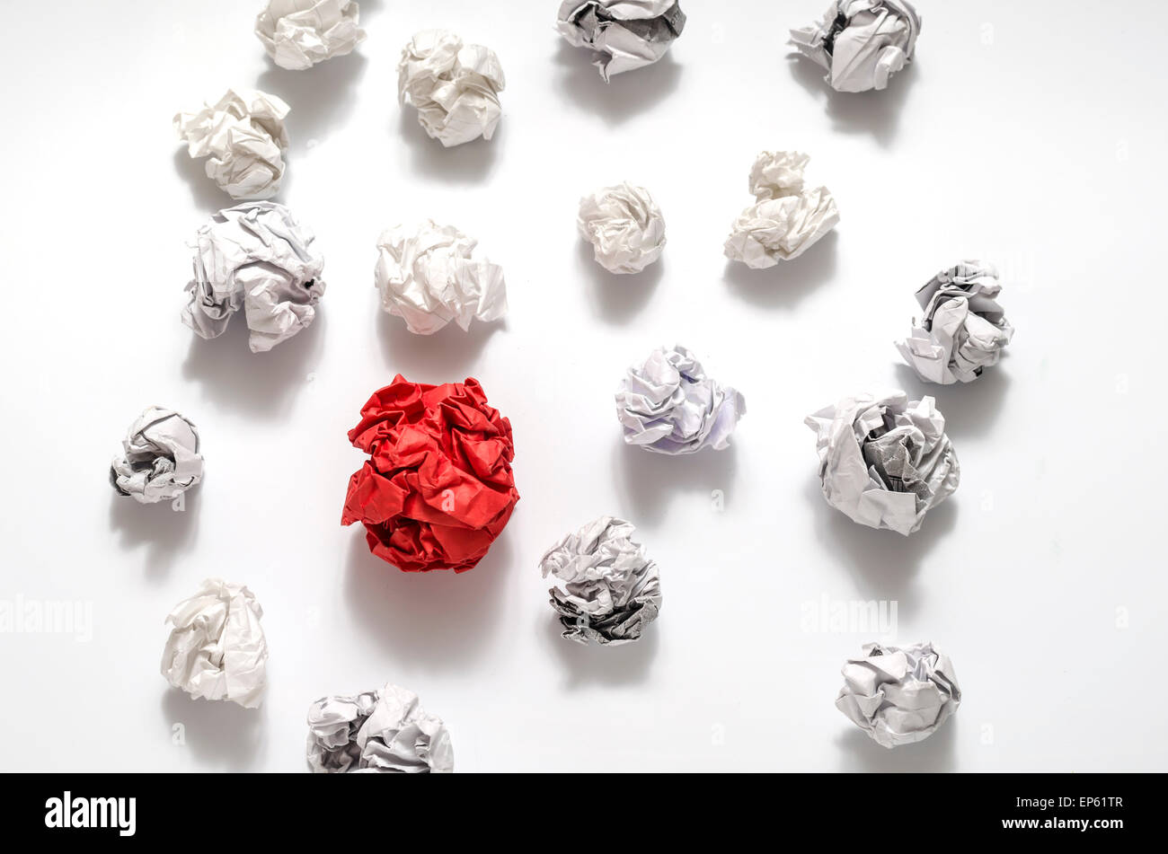 white crumpled paper ball and different red crumpled paper ball on a ...