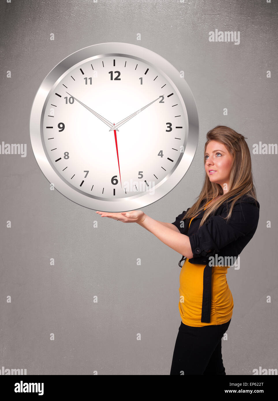 Attractive lady holding a huge clock Stock Photo - Alamy