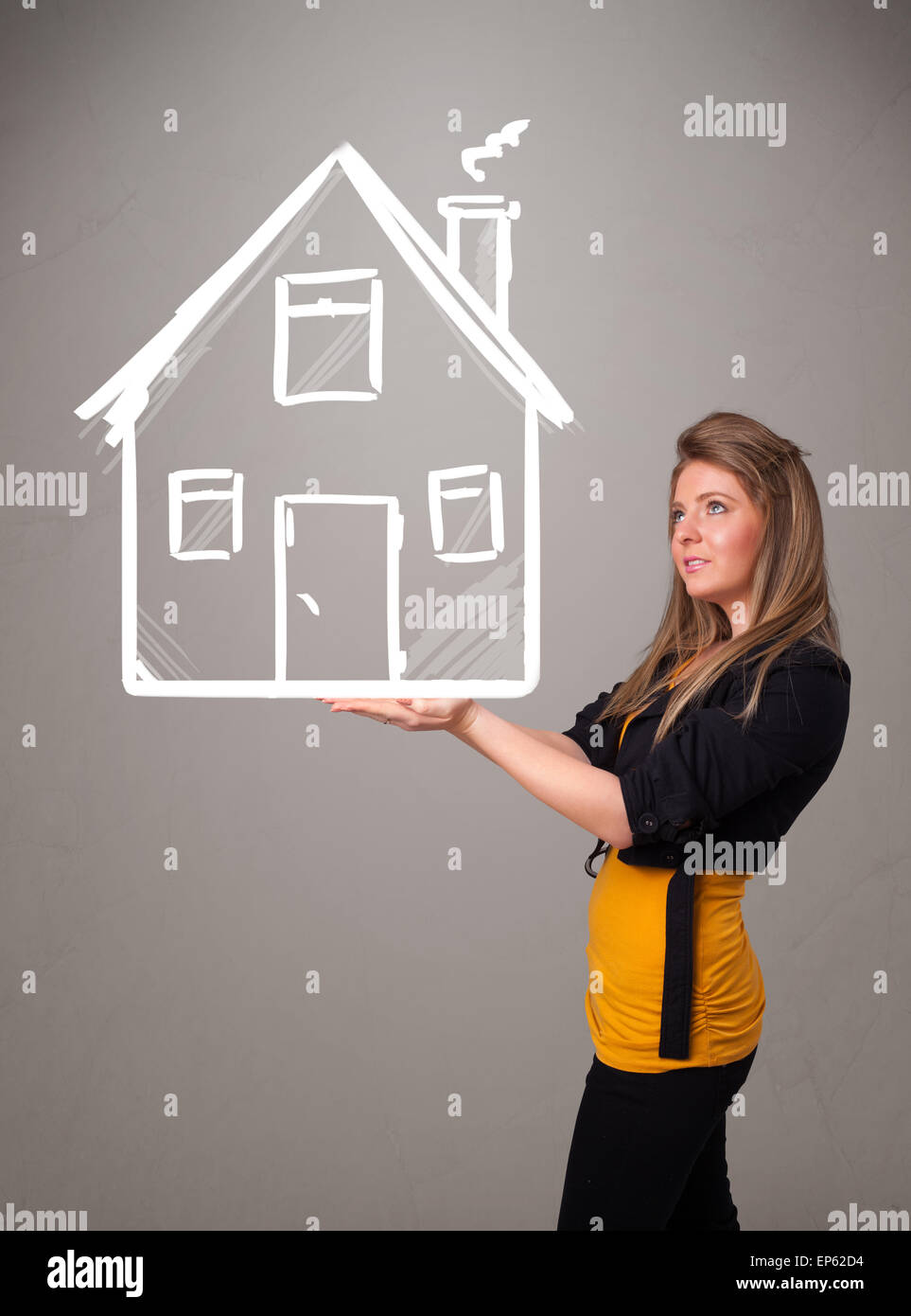 Young lady holding a huge drawn house Stock Photo - Alamy