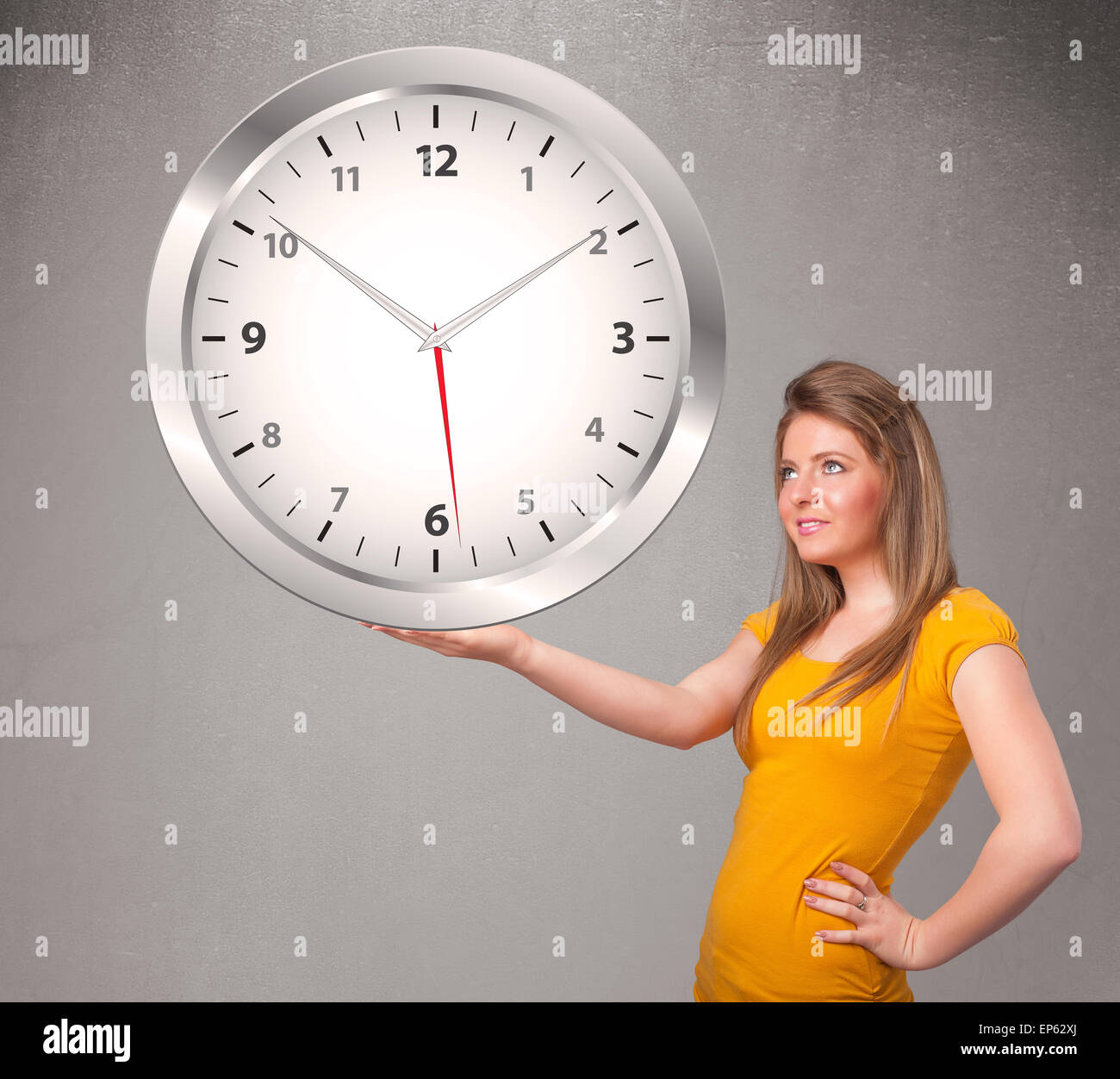 Attractive lady holding a huge clock Stock Photo - Alamy