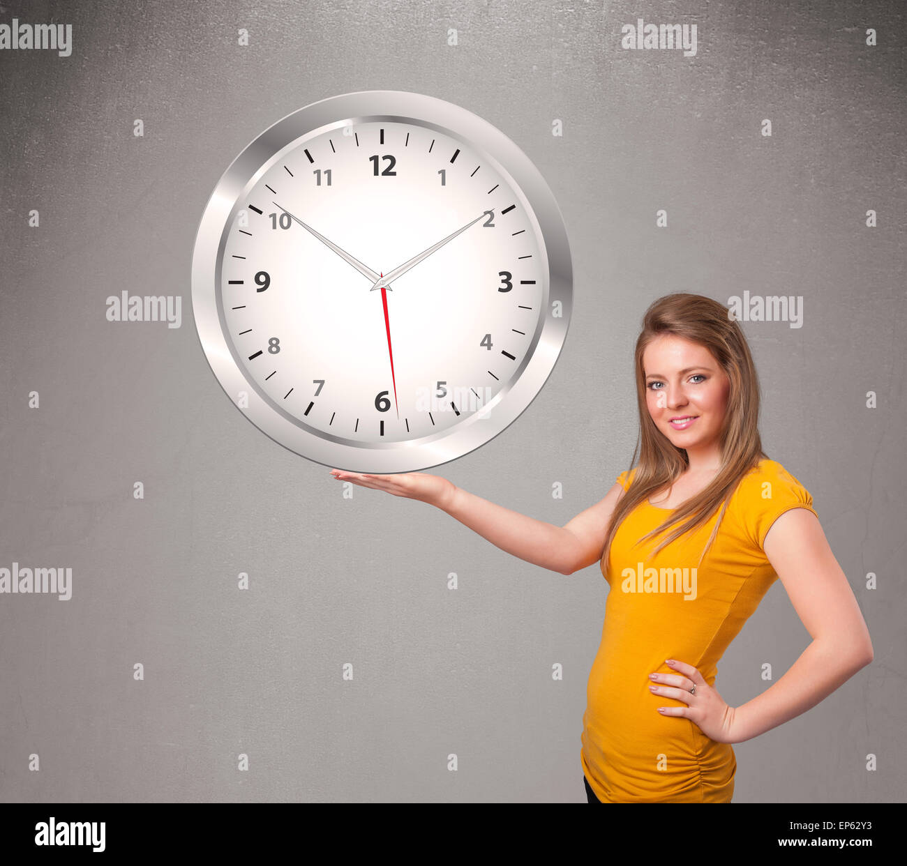 Attractive lady holding a huge clock Stock Photo - Alamy