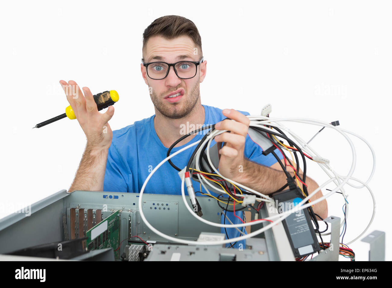 Portrait of confused it professional with screw driver and cables in ...