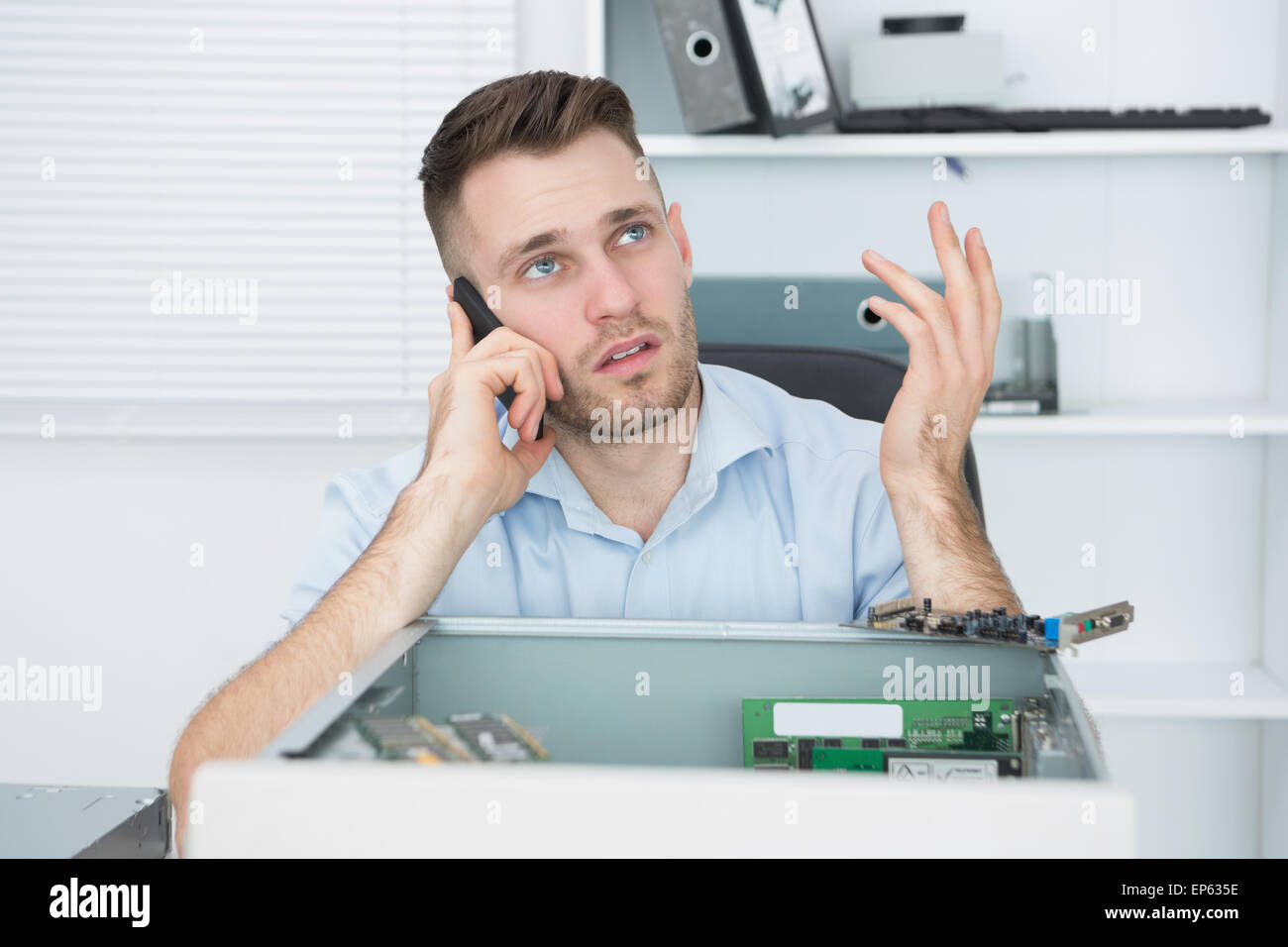 Worried computer engineer on call in front of open cpu Stock Photo - Alamy