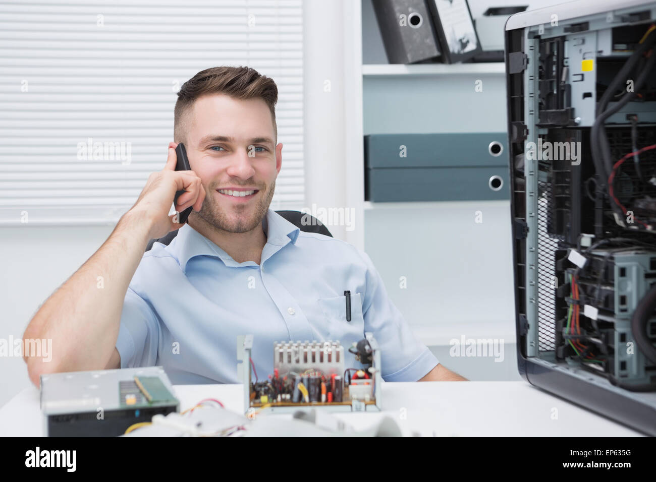 Smiling computer engineer on call by open cpu Stock Photo - Alamy