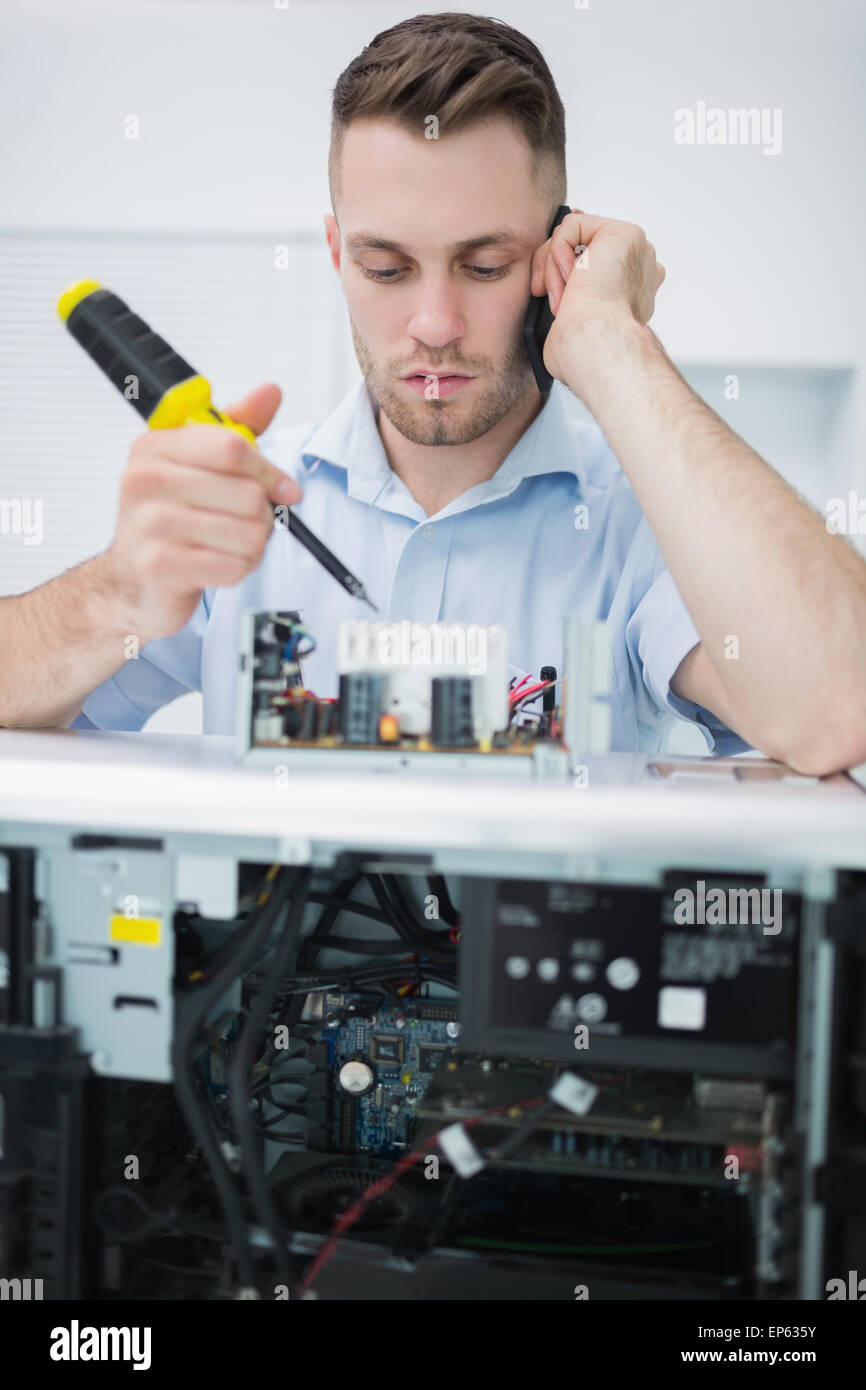 Computer engineer working on cpu part while on call in front of open ...