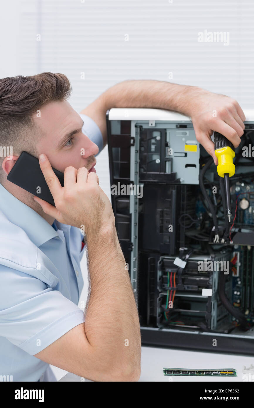 Young computer engineer working on cpu while on call Stock Photo - Alamy