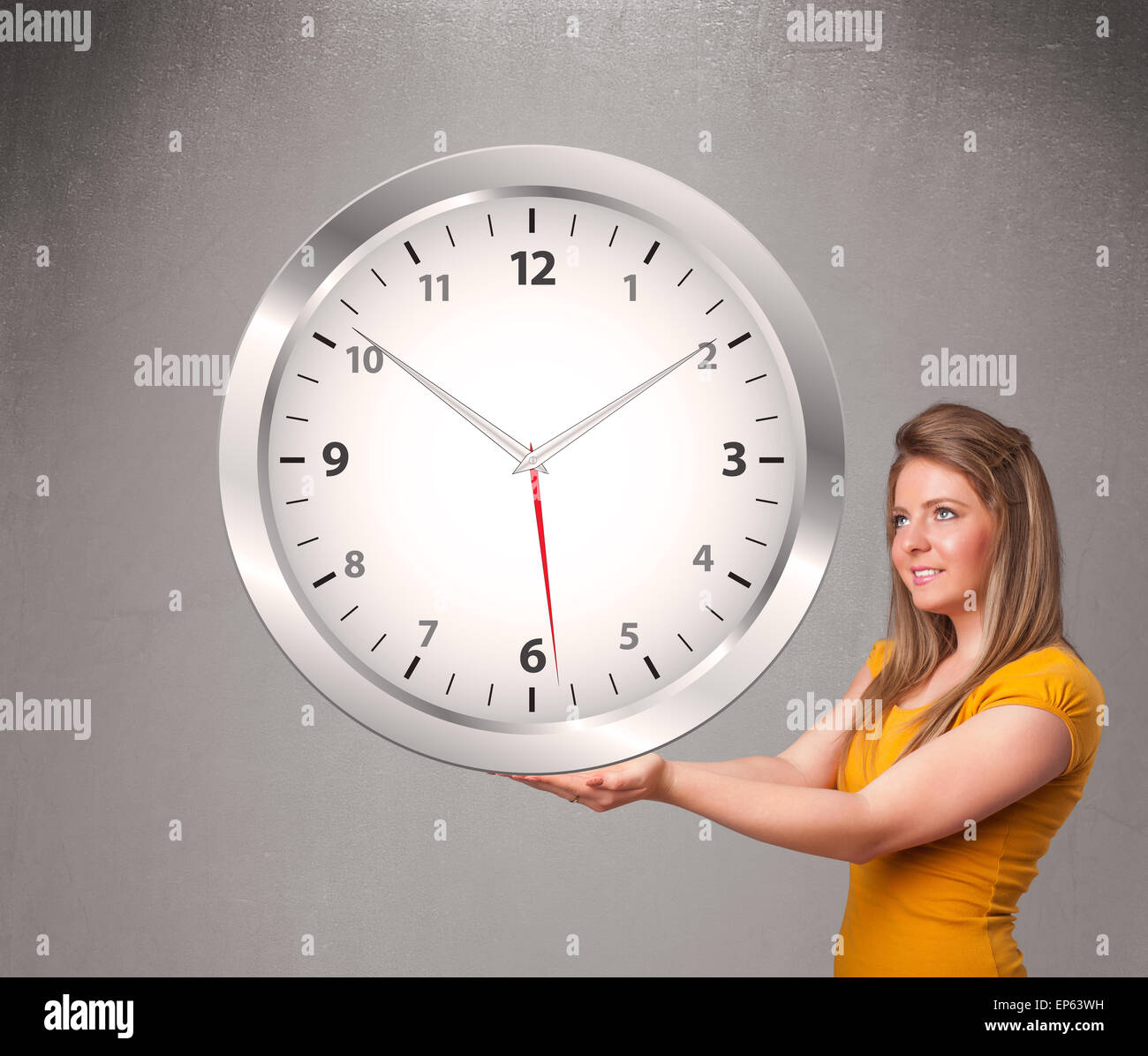 Attractive lady holding a huge clock Stock Photo - Alamy