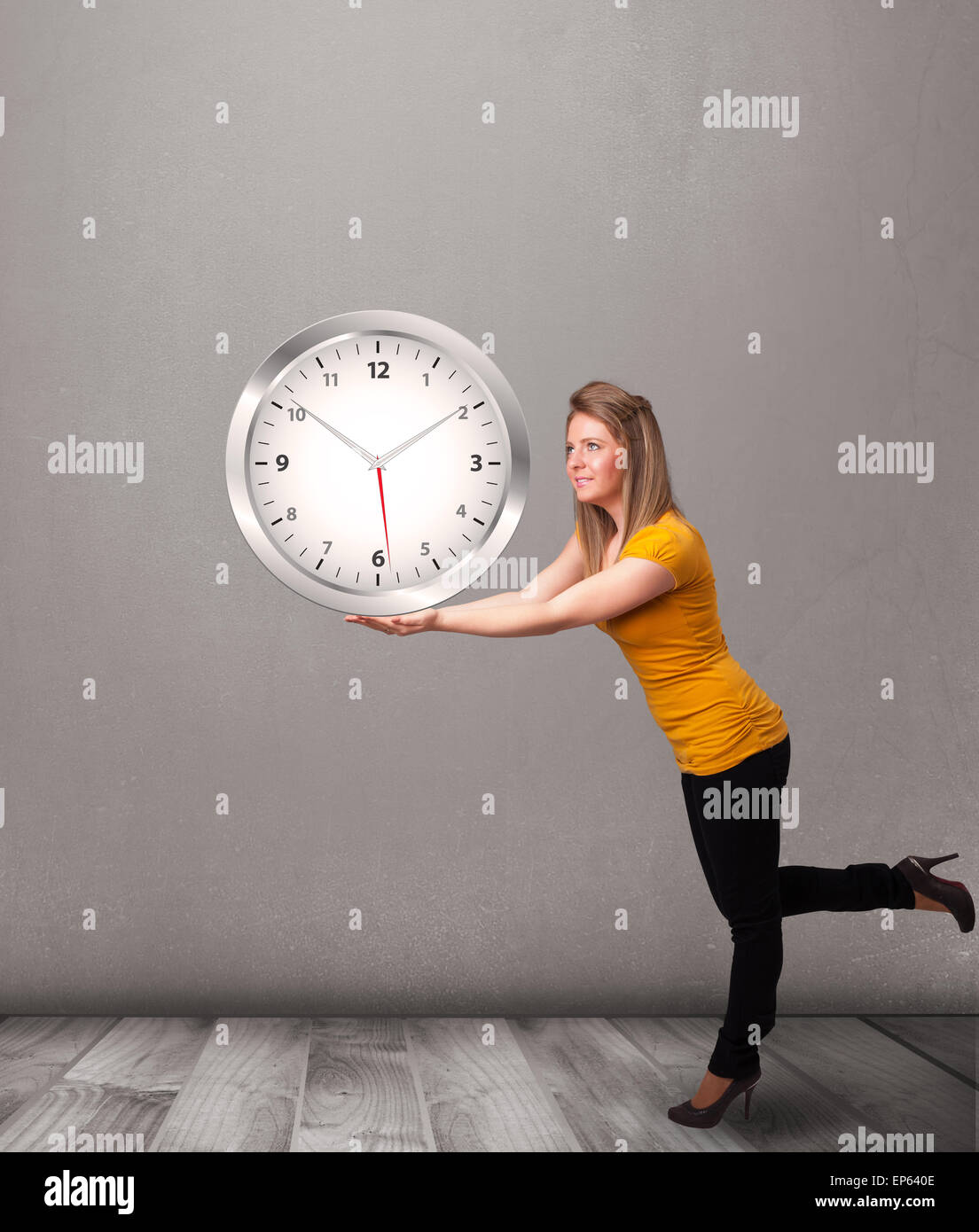Attractive lady holding a huge clock Stock Photo - Alamy