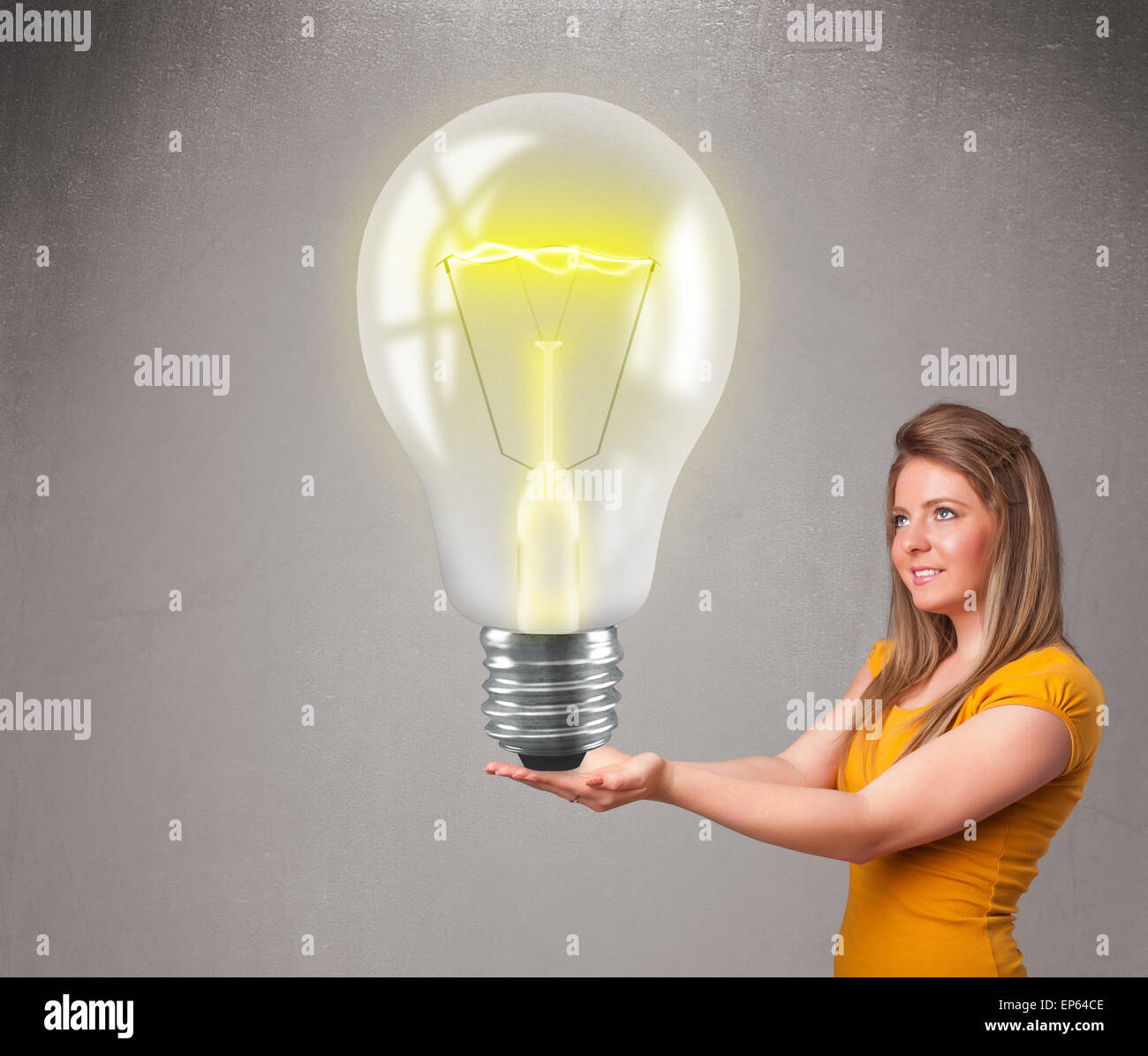 Beautiful lady holding realistic 3d light bulb Stock Photo - Alamy