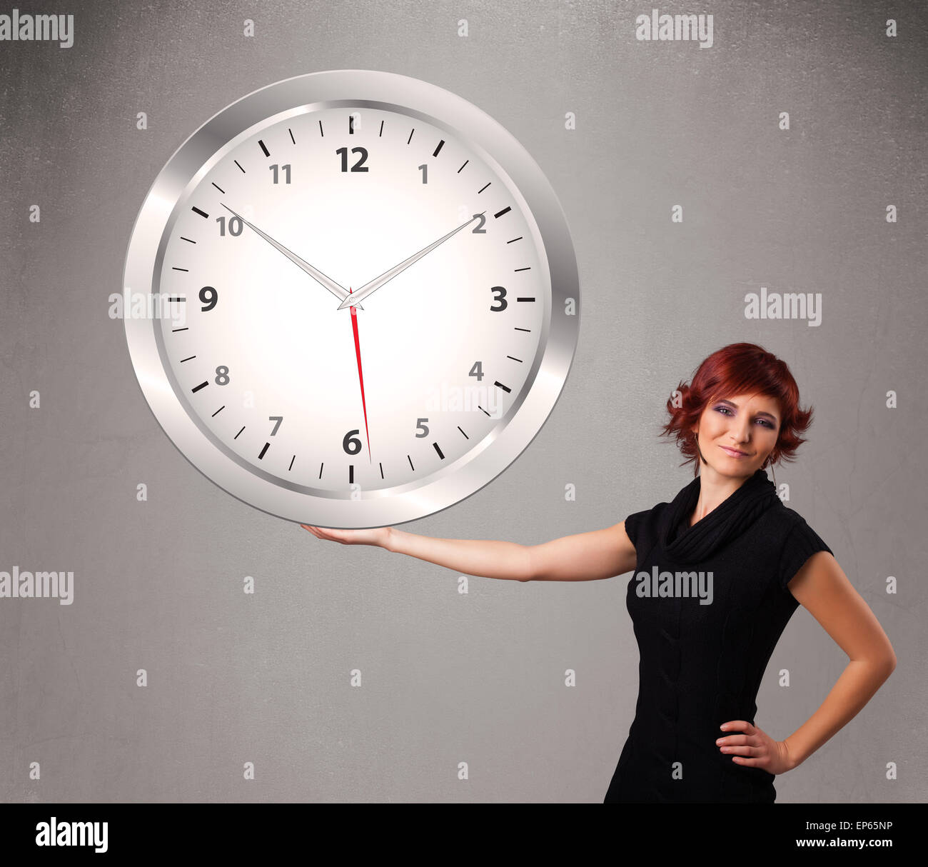 Attractive lady holding a huge clock Stock Photo - Alamy