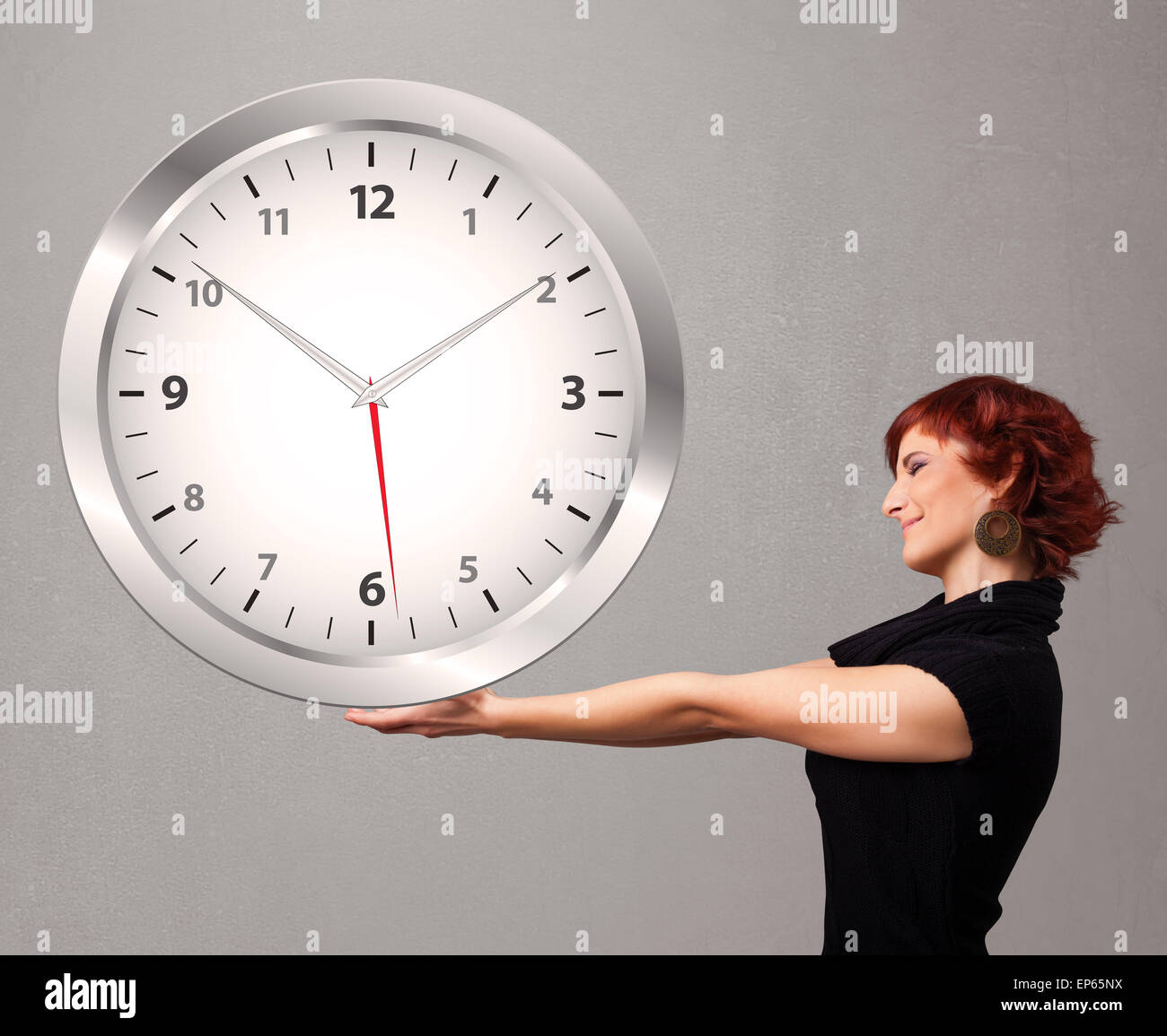 Attractive lady holding a huge clock Stock Photo - Alamy