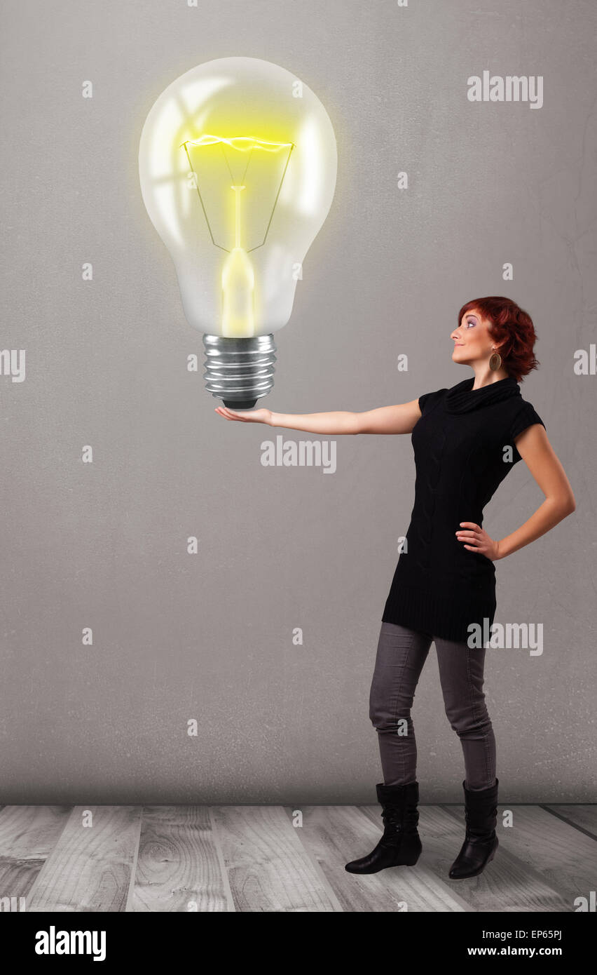 Beautiful lady holding realistic 3d light bulb Stock Photo - Alamy