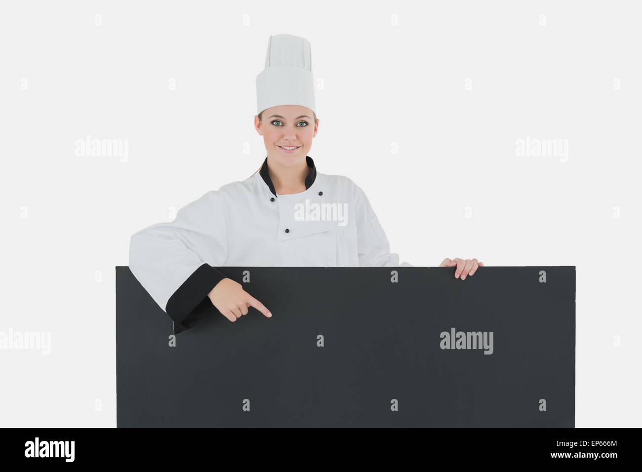 Happy female chef pointing at black billboard Stock Photo - Alamy