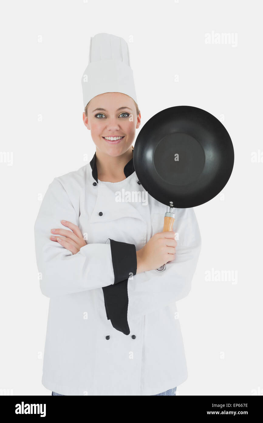 Female chef with arms crossed holds frying pan Stock Photo - Alamy