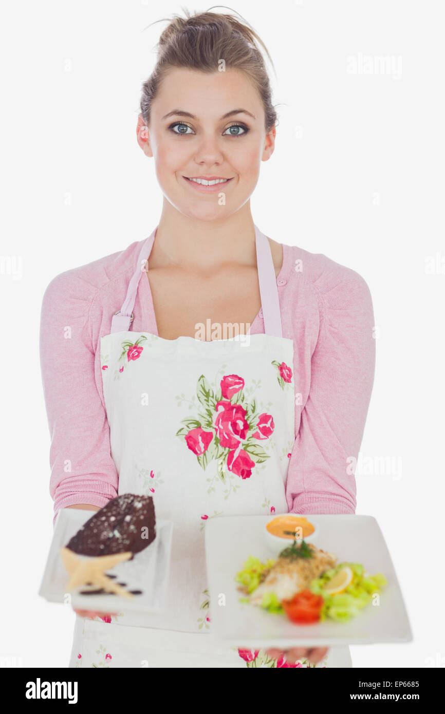 Beautiful maid holding plates of pastry and healthy food Stock Photo ...