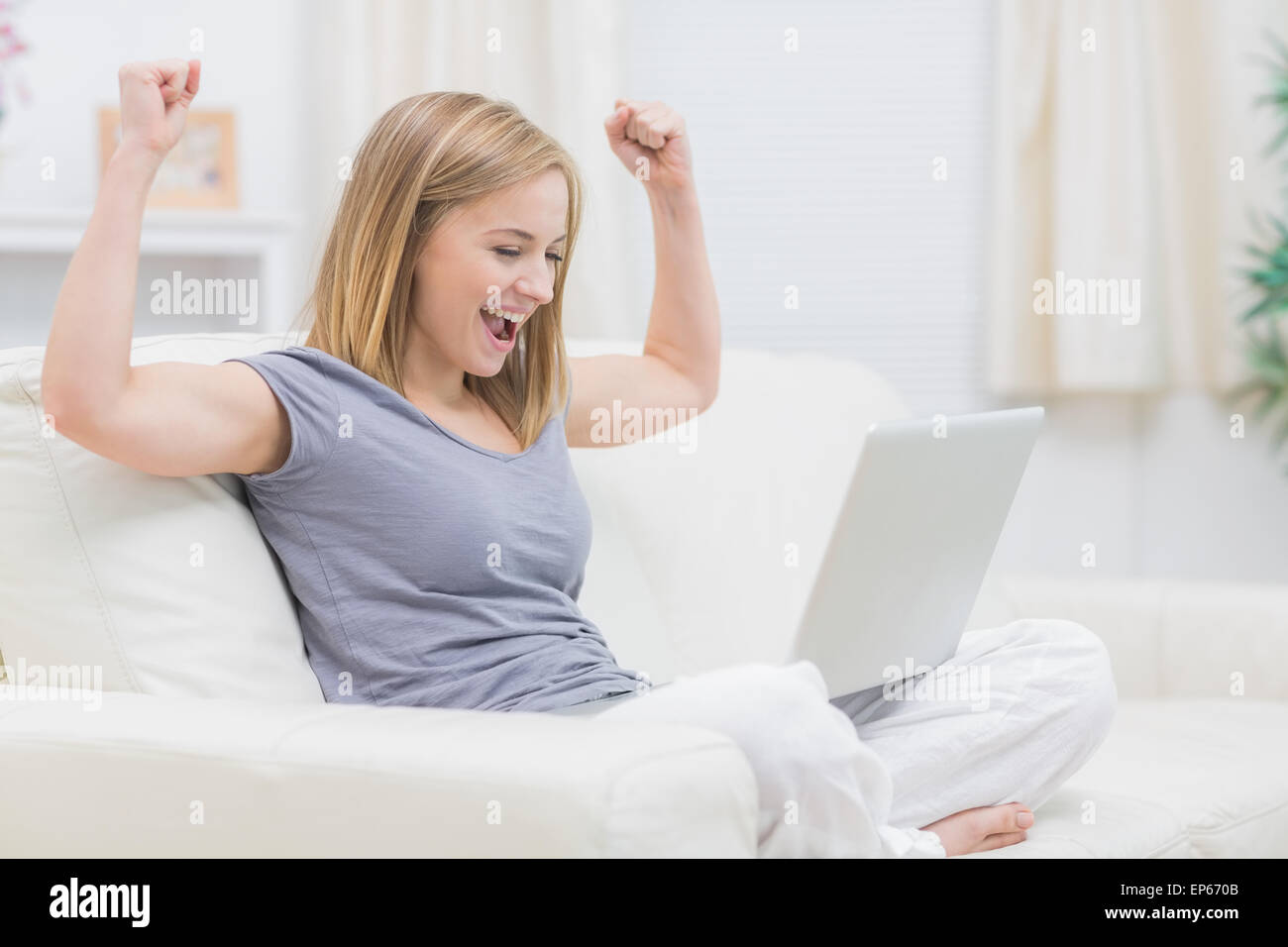 Excited woman looking at laptop screen at home Stock Photo - Alamy