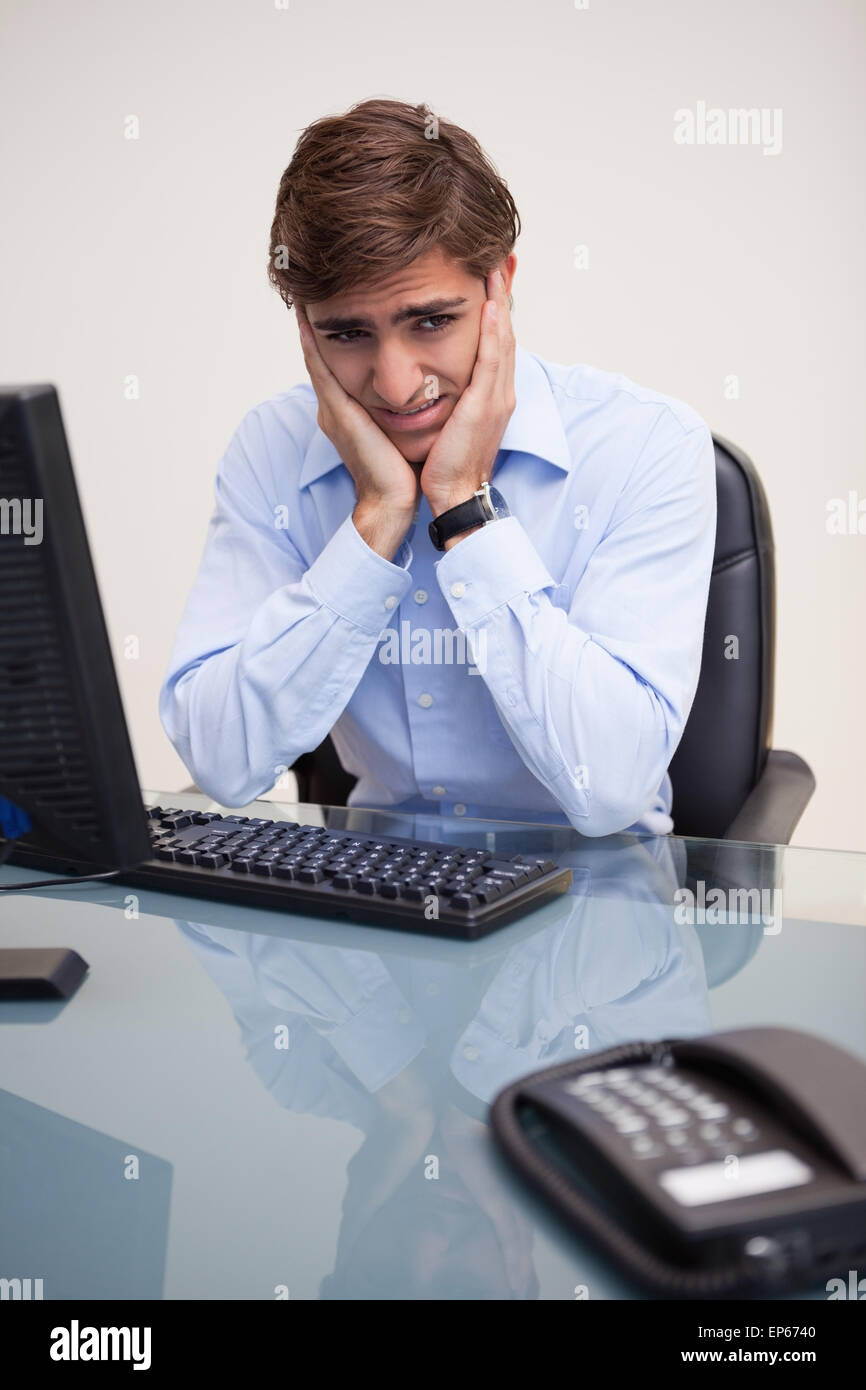 Young worried business man sitting at office desk Stock Photo - Alamy