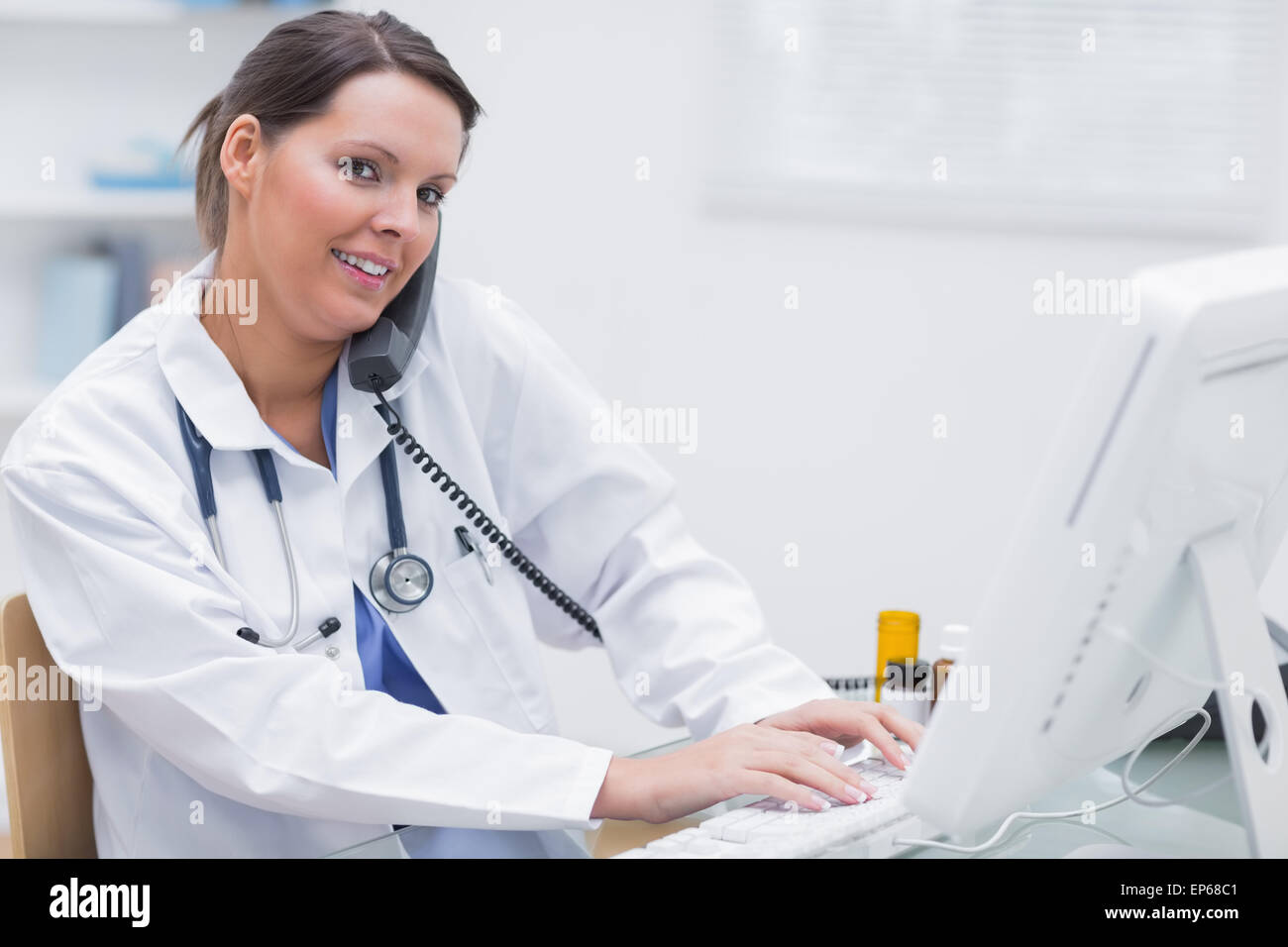 Female doctor using computer while on call at clinic Stock Photo - Alamy