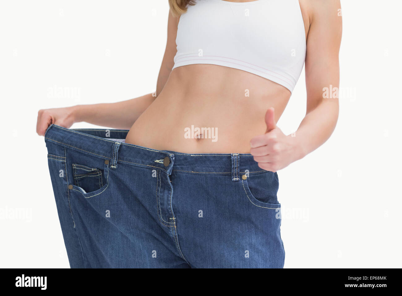 Midsection of woman wearing old pants after losing weight and gesturing ...