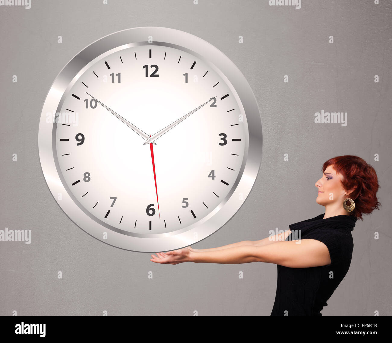 Attractive lady holding a huge clock Stock Photo - Alamy