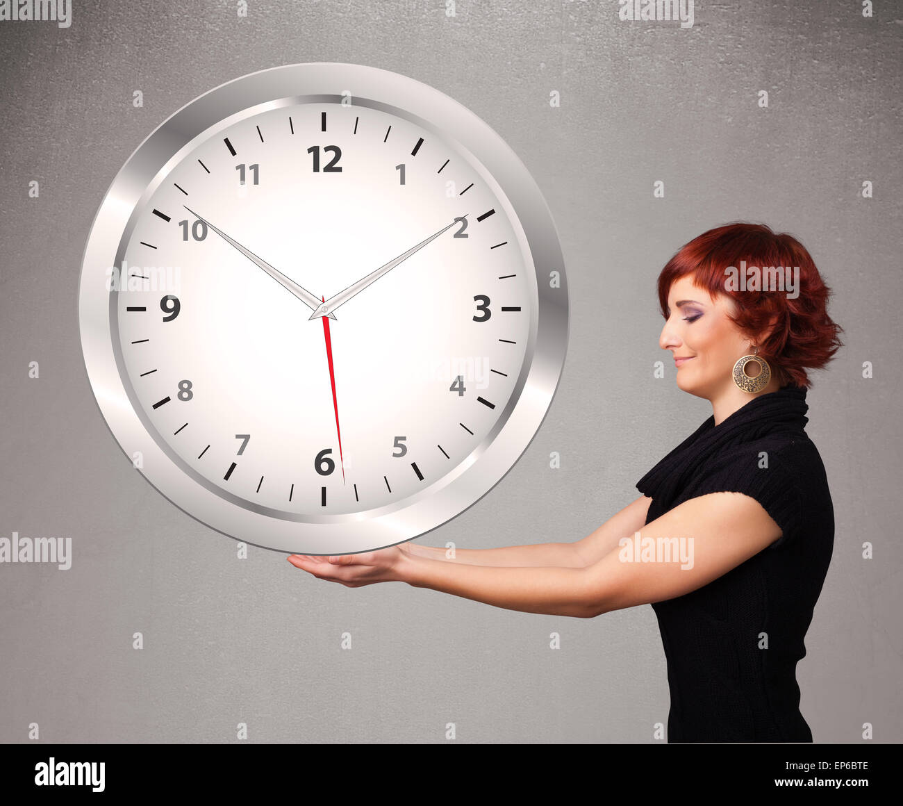 Attractive lady holding a huge clock Stock Photo - Alamy