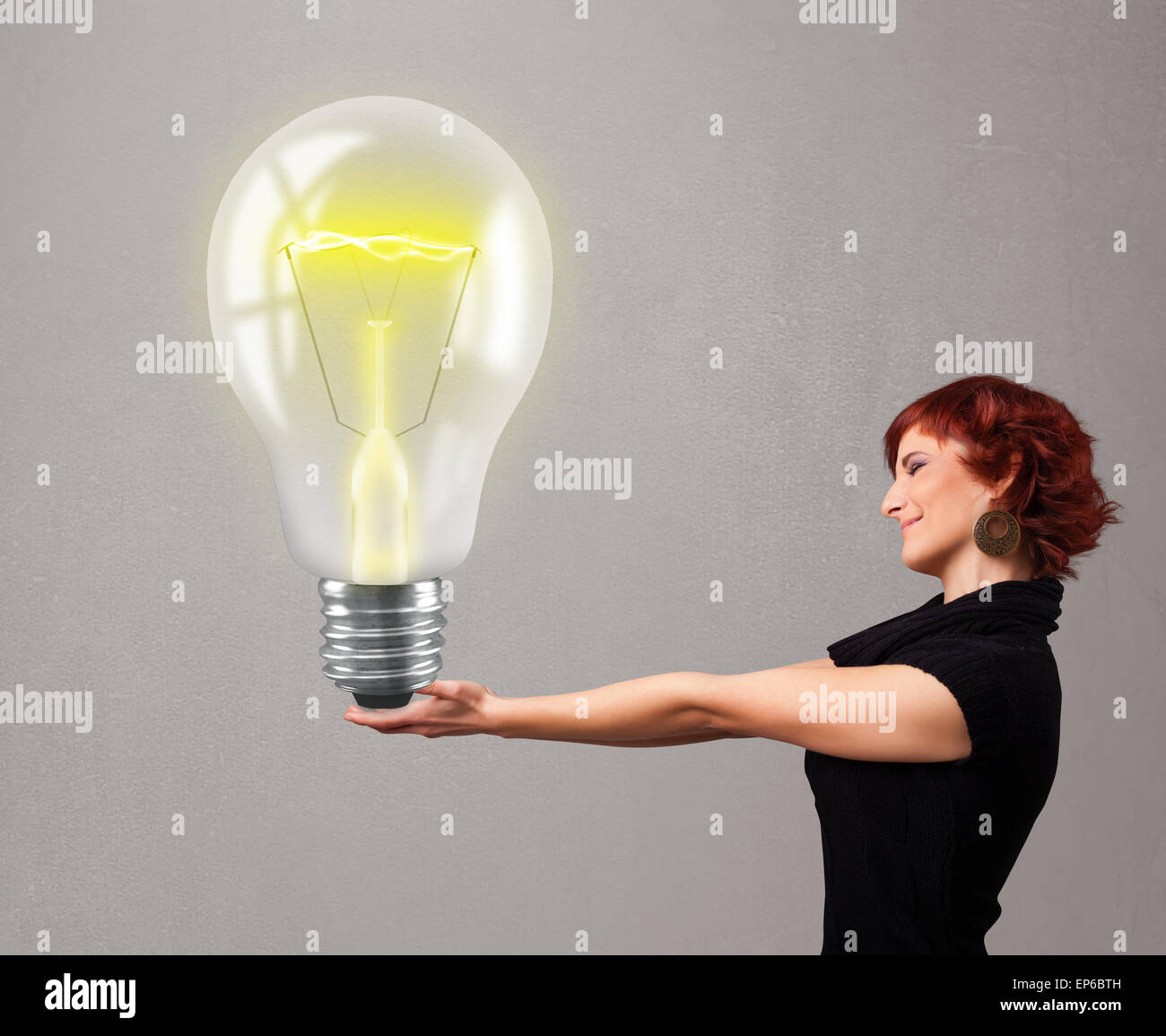 Beautiful lady holding realistic 3d light bulb Stock Photo - Alamy