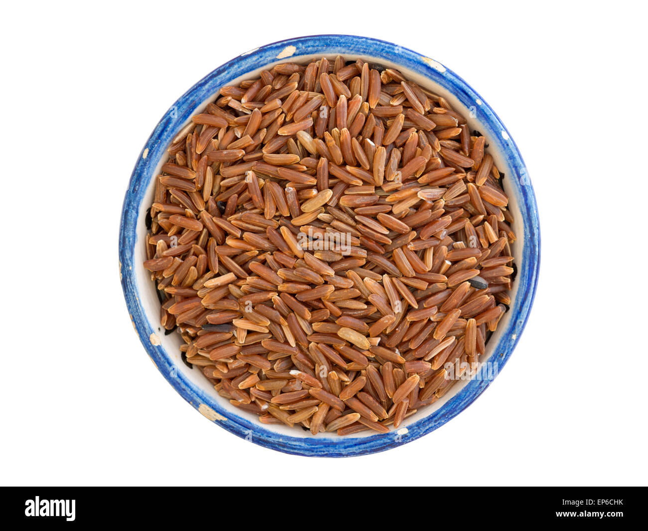 many dry ruby rice corns in small blue cup isolated on white Stock ...